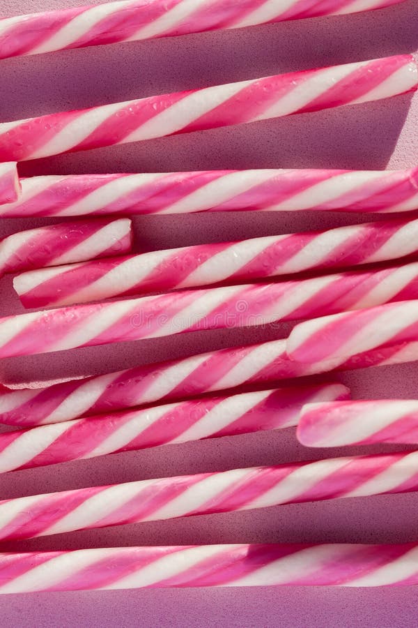 Striped Pink and White Candy Sticks Arranged on a Pastel Background ...