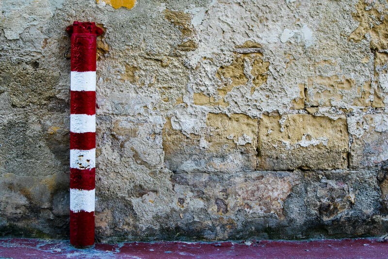 Striped Red and White Pole Against a Textured Wall Stock Image - Image ...