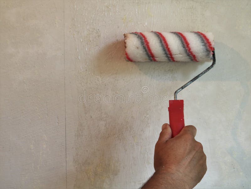 Striped Roller in Hand on a Wall Covered with Glue Stock Photo - Image ...