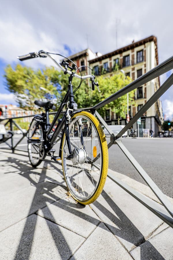 A Stroller Bicycle Leaning on a Metal Railing on an Urban Street Stock ...