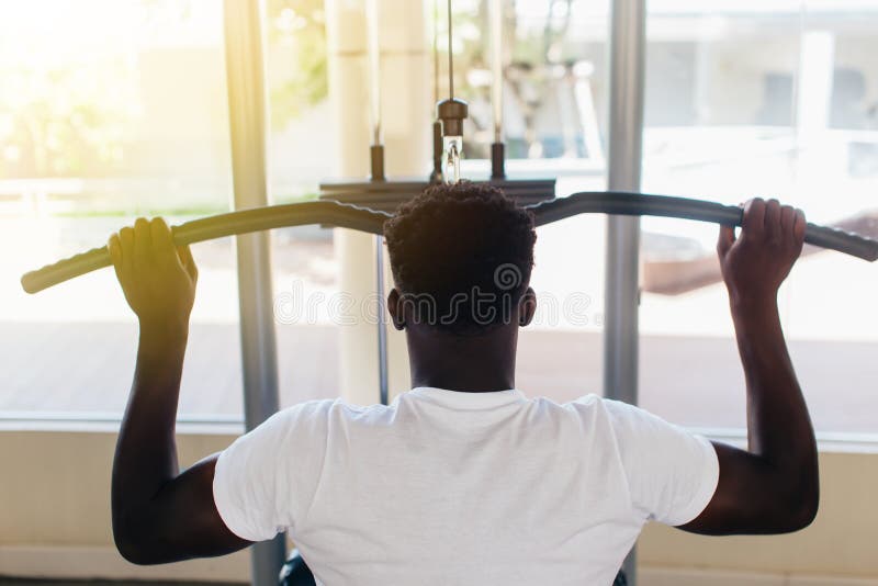 Strong African American Man in Sportswear Pulling Cable with Bar while ...