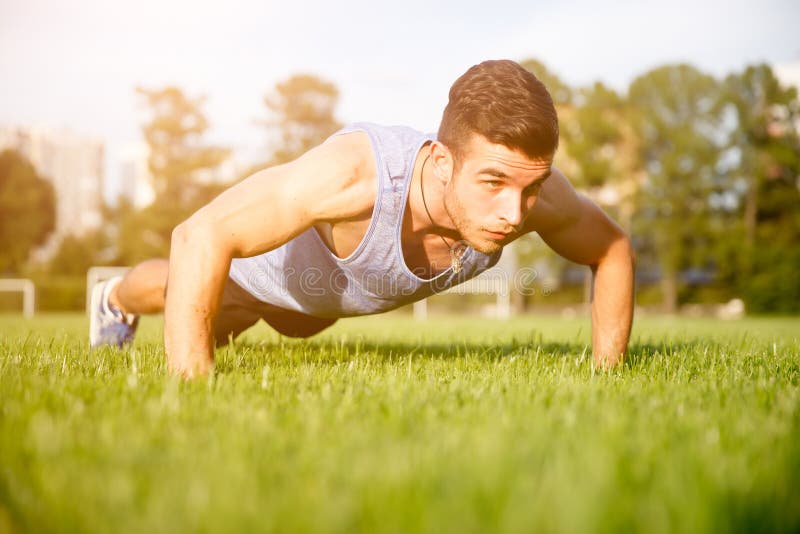 Strong Athletic Man Doing Exercises on Sports Field Stock Image - Image ...