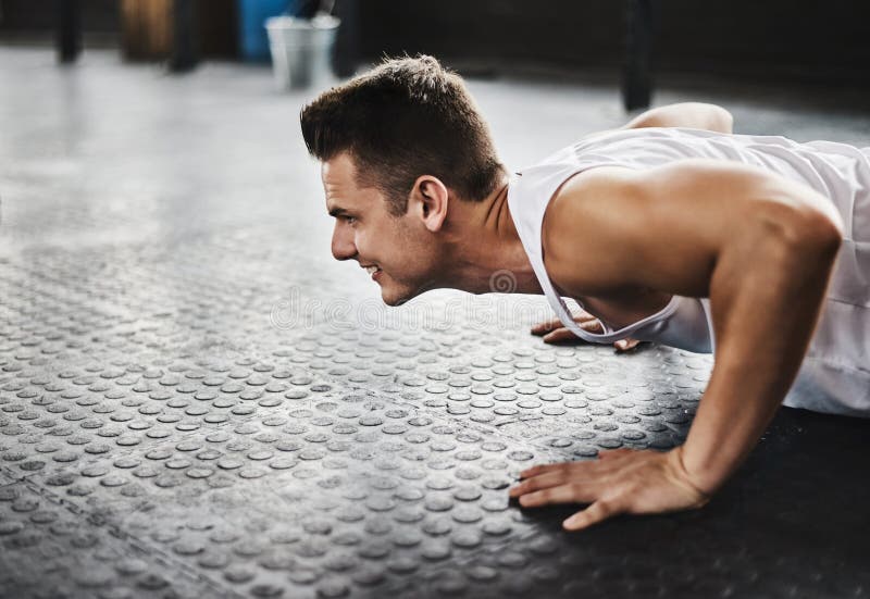 Strong Bodies Need a Strong Mindset. a Young Man Doing Pushups in a Gym ...