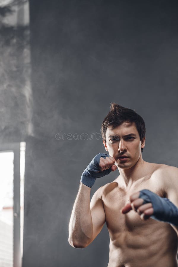 Strong Boxer in the Rays of the Sun and Smoke Training Hands with ...