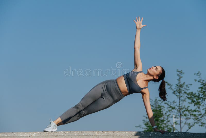 Strong Brunette Exercising Outdoors, Standing on Her Side Stock Image ...