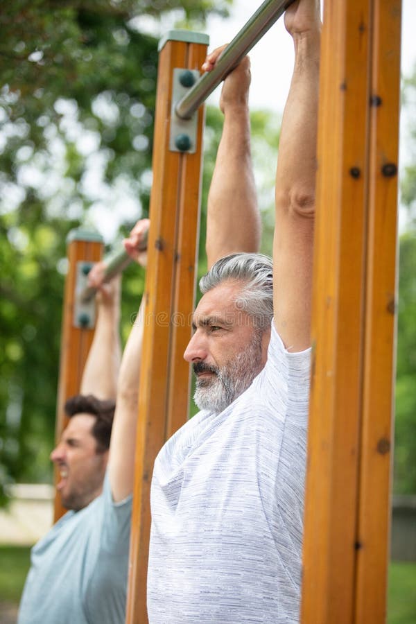 Strong and Competitive Men Exercising on Monkey Bars Stock Image ...