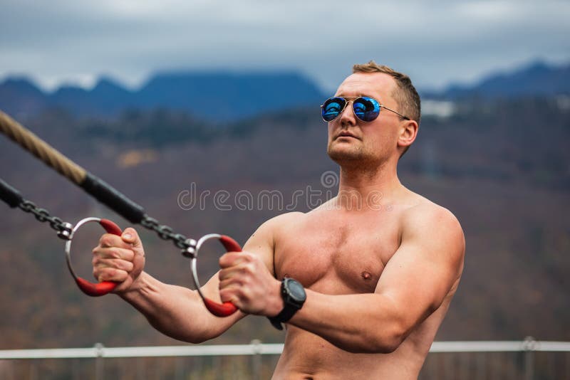 Strong Male Athlete Exercising on a Gymnastics Bars. Workout in the ...