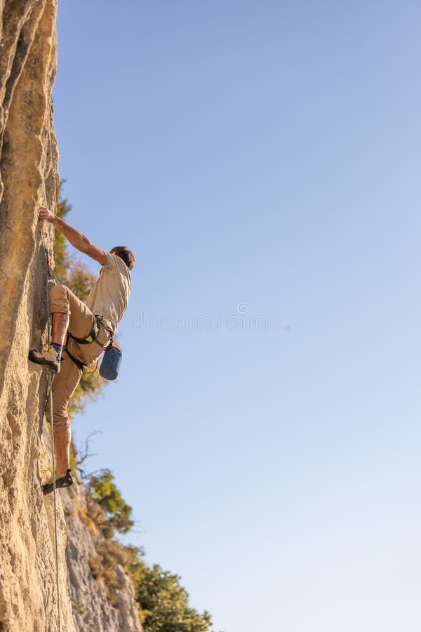 A strong man climbs a rock stock image. Image of outdoor - 263456989