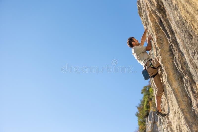 A strong man climbs a rock stock image. Image of climbing - 263457117