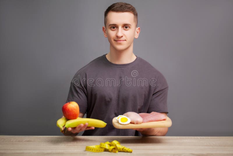 Strong Man Consumes a High-protein Meal of Meat and Fruit Stock Photo ...