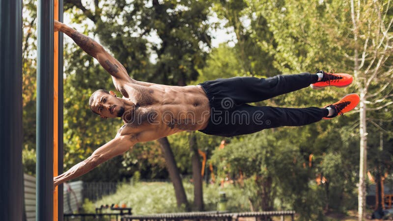 Strong Man Practicing Human Flag Exercise, Gripping Vertical Bar Stock ...