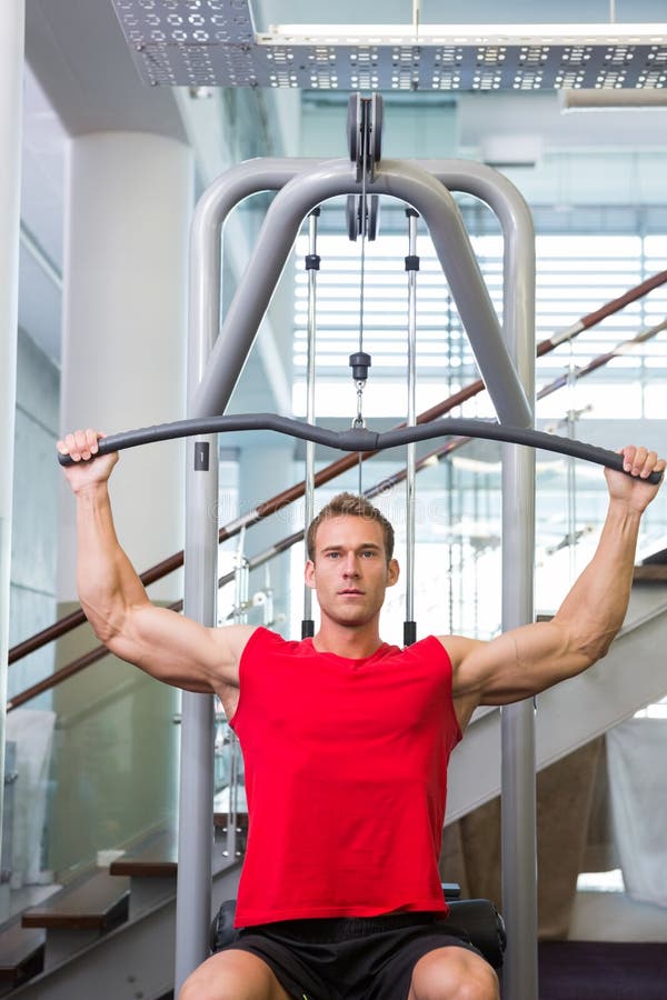 Strong Man Using Weights Machine for Arms Stock Photo - Image of rear ...