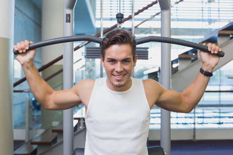 Strong Man Using Weights Machine for Arms Stock Photo - Image of front ...