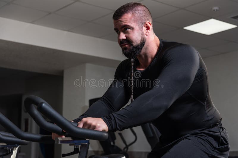 Working Out on the Exercise Bicycle in the Gym Stock Photo - Image of ...