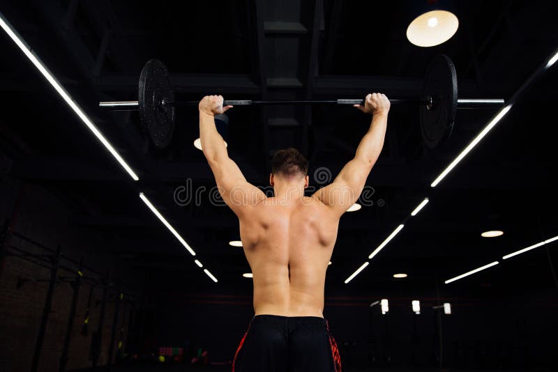 Strong Man Working Out at a Gym with Bar Plate. Pulls Up. Stock Image ...