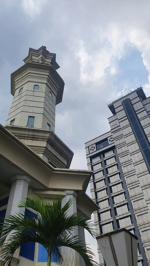 Strong Mosque Tower and Great Skyscraper Building with Cloudly Blue Sky ...