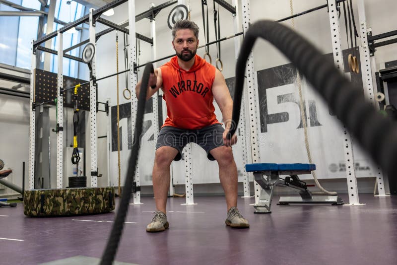 Strong Powerful Man Working Out with Battle Ropes at Gym, Developing ...