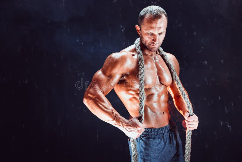 Strong man with rope stock image. Image of bodybuilder - 101423057