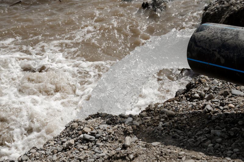 A Strong Stream of Water Pouring from a Plastic Water Pipe into a River ...