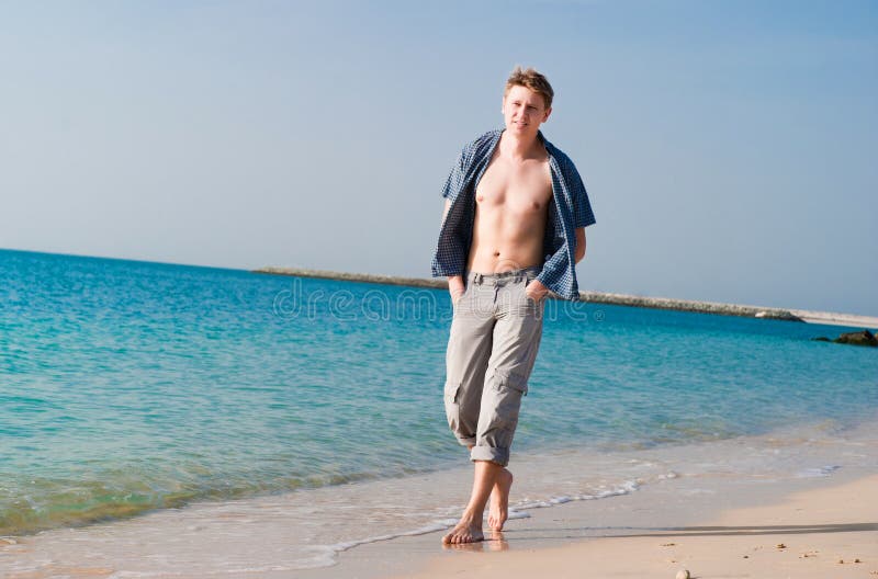 Strong young man at beach stock photo. Image of alone - 24704842