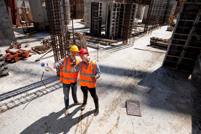 Structural Engineer and Architect Dressed in Orange Work Vests and Hard ...
