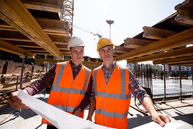 Structural Engineer and Architect Dressed in Shirts, Orange Work Vests ...