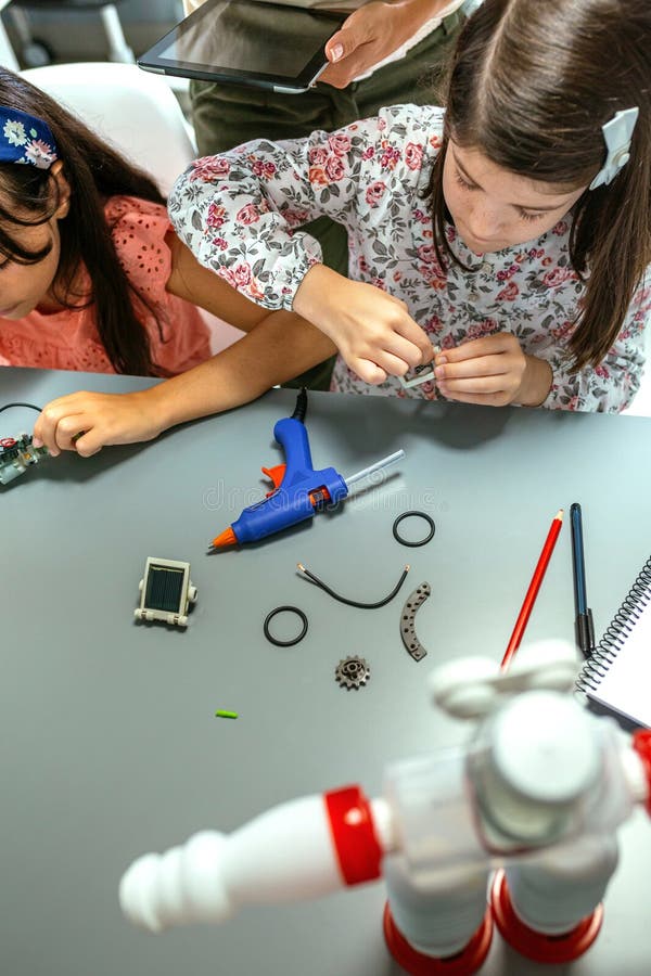 Student Assembling Machine Pieces Next To Her Teacher and To ...