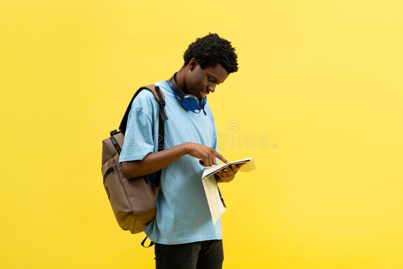 Student with Backpack Reading Map on Yellow Background Stock Image ...