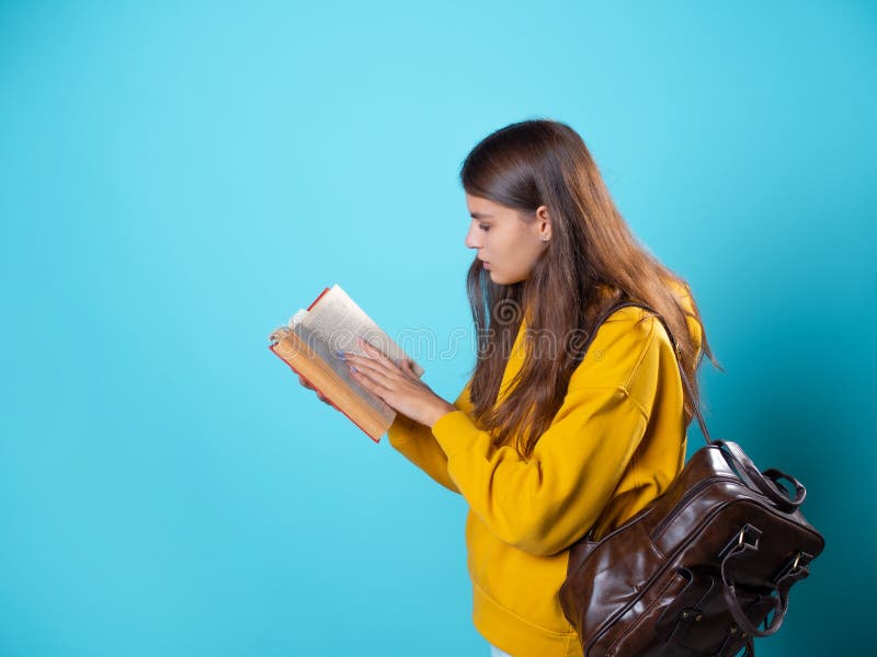 A Student with a Book in Her Hands, Reading a Textbook and Preparing ...