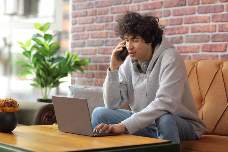 Student in a Cafe Sitting on a Sofa and Using a Laptop Computer Stock ...