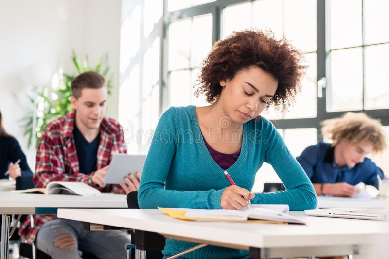 Student Concentrating while Writing an Essay during Class in an Stock ...