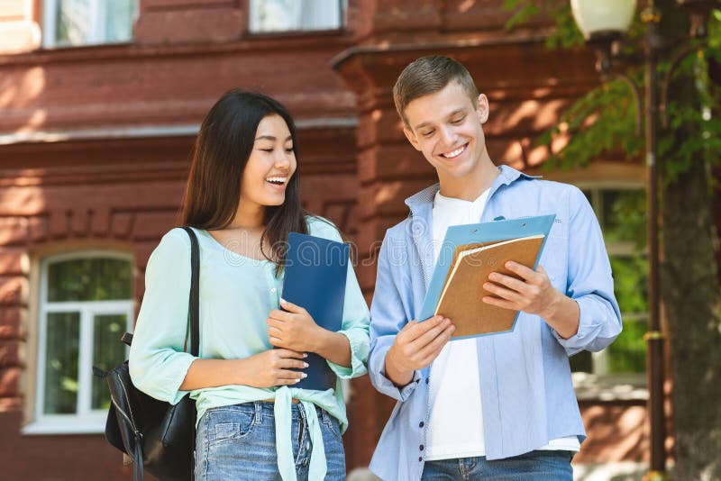 Student Couple Going To Class, Checking Lessons Schedule Outdoors and ...