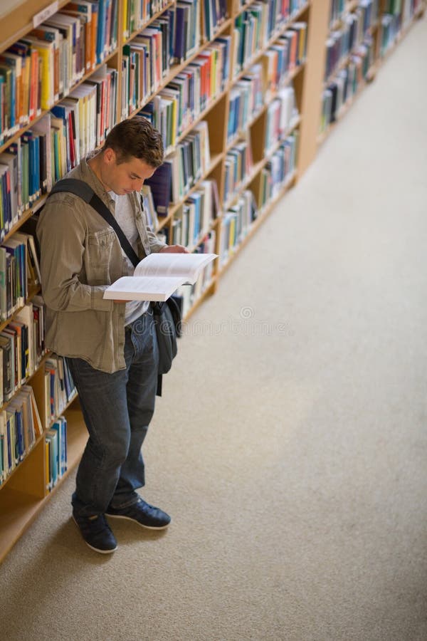Student, Der Ein Buch Steht in Der Bibliothek Liest Stockfoto - Bild ...
