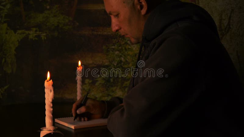 Student Do Homework at Night with Candles. Student Writing in Notebook ...
