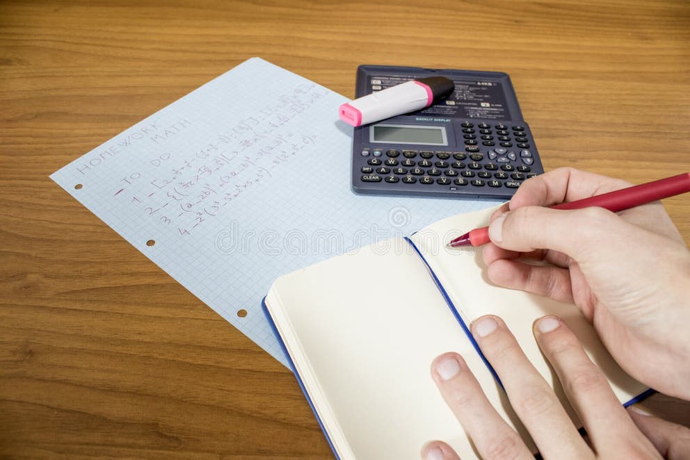 A Student is Doing Math Homework with a Calculator a Pen and a N Stock ...