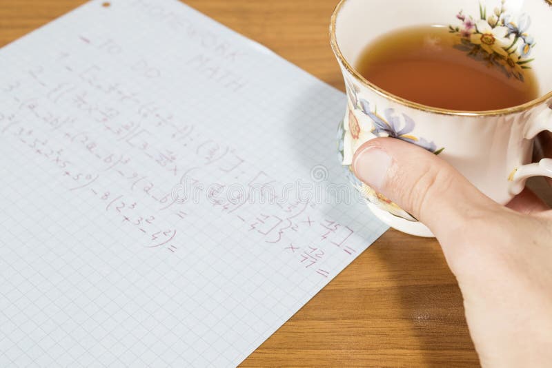 A Student is Doing Math Homework with a Cup of Tea in His Hand Stock ...