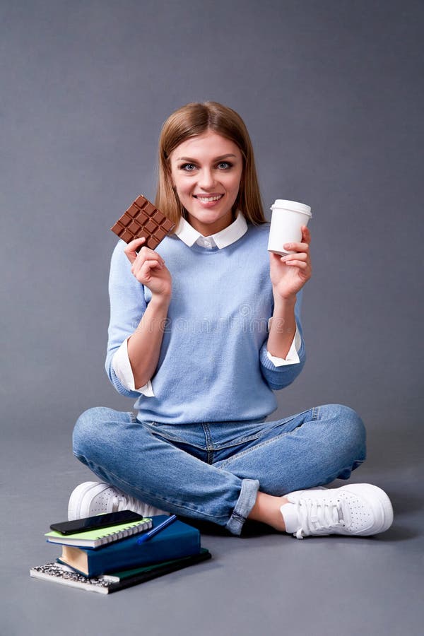 A Student Eats a Candy Bar, Drinking Coffee and Smiling. Student ...