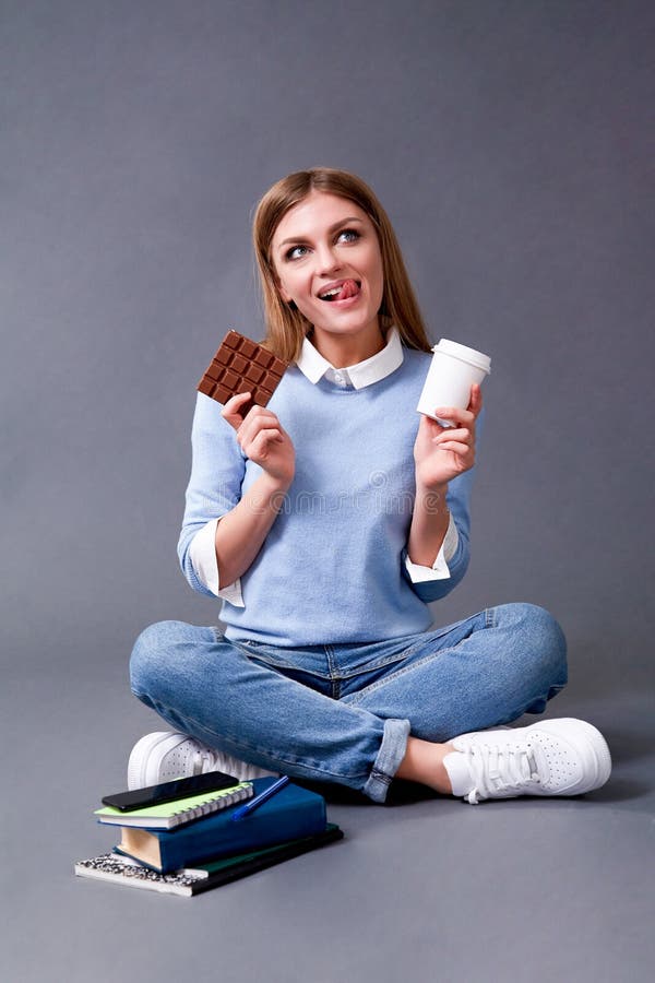A Student Eats a Candy Bar, Drinking Coffee and Smiling. Student ...