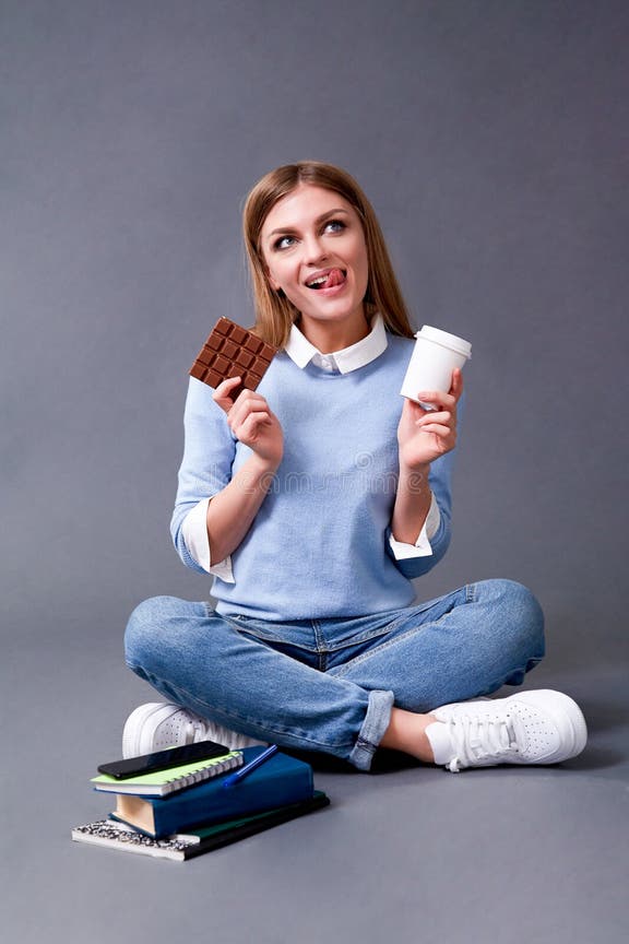 A Student Eats a Candy Bar, Drinking Coffee and Smiling. Student ...