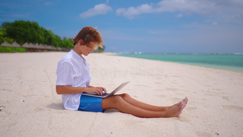 A Student is Engaged in Self-education Sitting on the Beach Against the ...