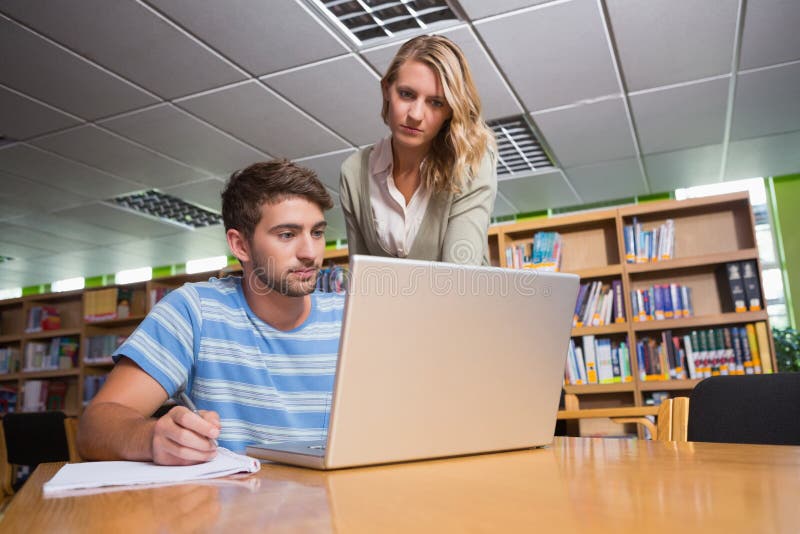Student Getting Help from Tutor in Library Stock Image - Image of ...