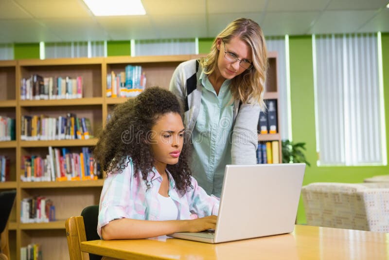 Student Getting Help from Tutor in Library Stock Photo - Image of ...