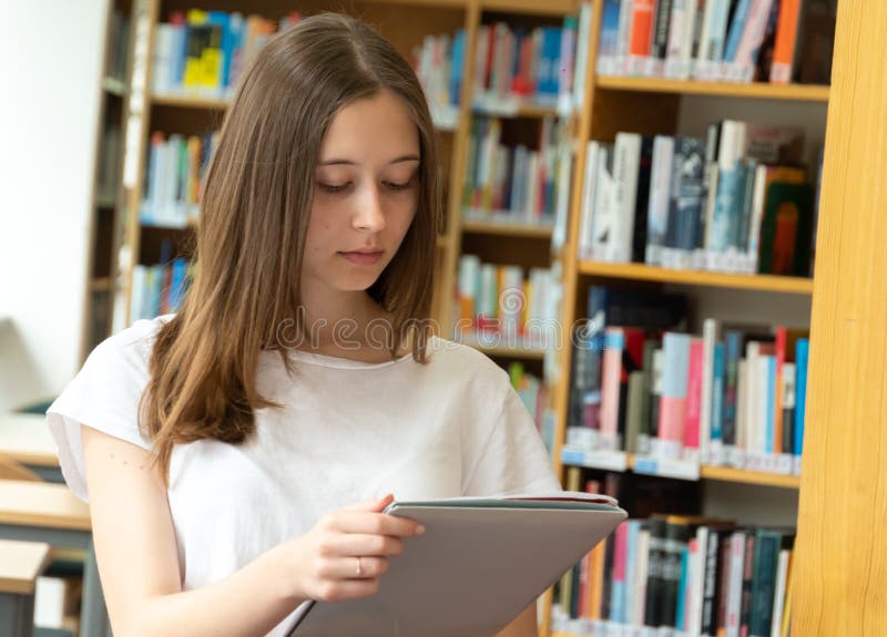 Student girl in a library stock photo. Image of notebook - 146081842