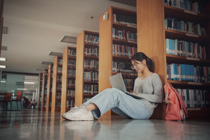 Student Girl Sitting on Floor and Using Laptop, Writes Notes for Paper ...