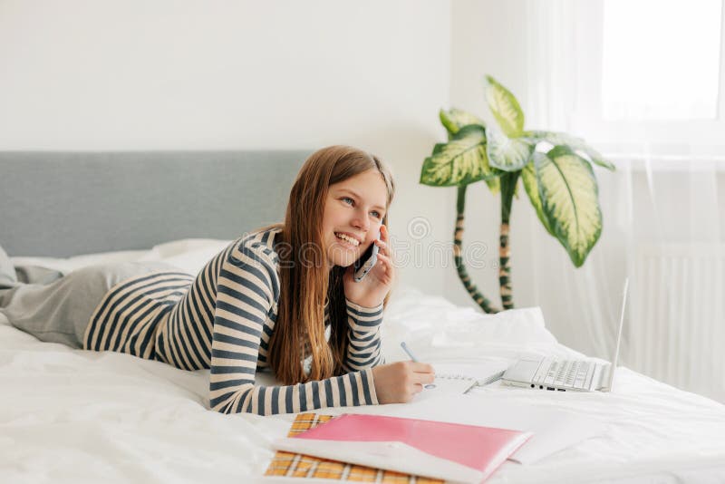 A Student Girl is Talking on the Phone, Discussing Homework with ...