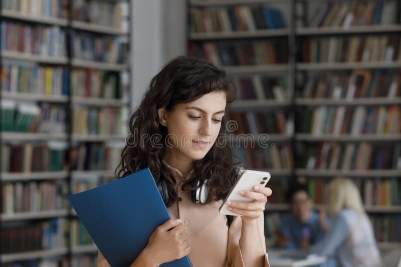 Student Girl Using Smartphone Standing in Library Stock Photo - Image ...