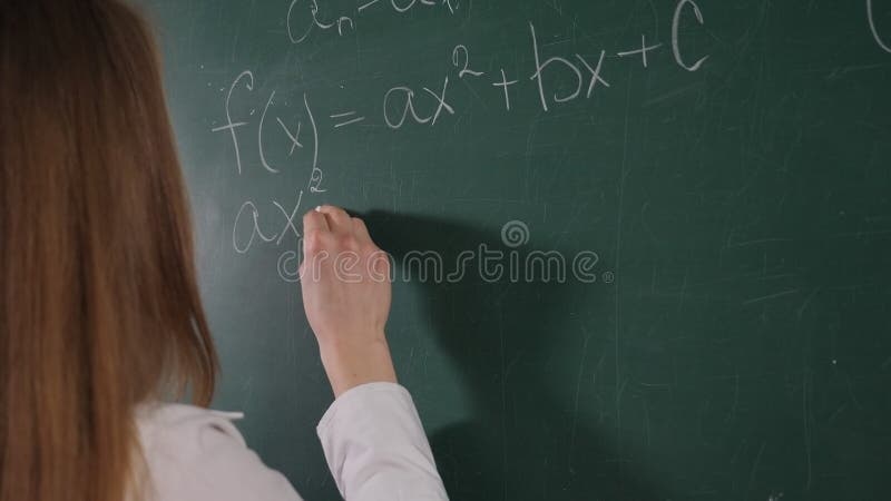 A Student Girl Writes Mathematical Formulas on a Blackboard with Chalk ...