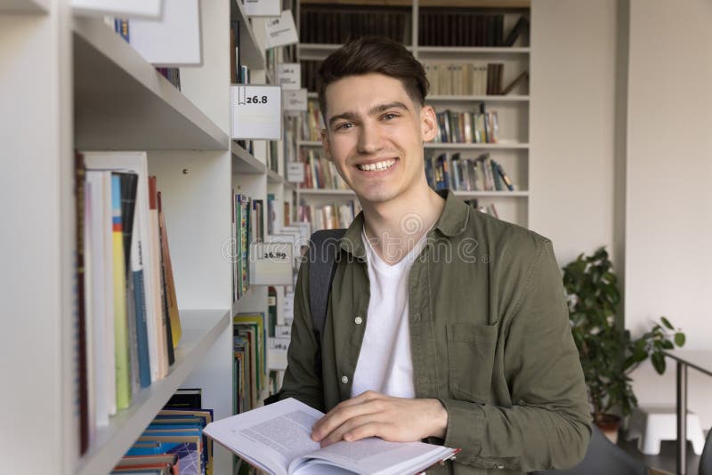 Student Guy Look at Camera Posing in Library with Textbook Stock Image ...