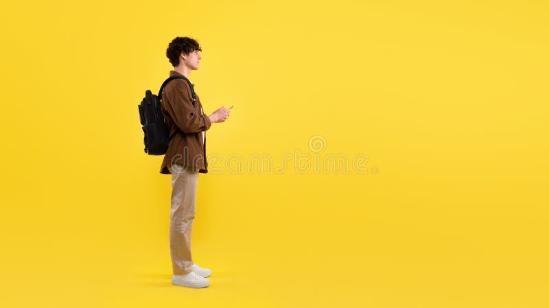 Student Guy Using Smartphone Pointing Finger Aside Over Yellow ...