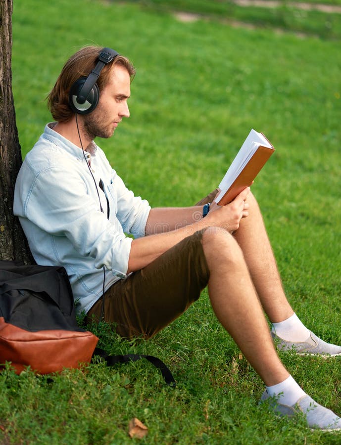 Student with Headphones in Park of Campus Read a Book Stock Image ...